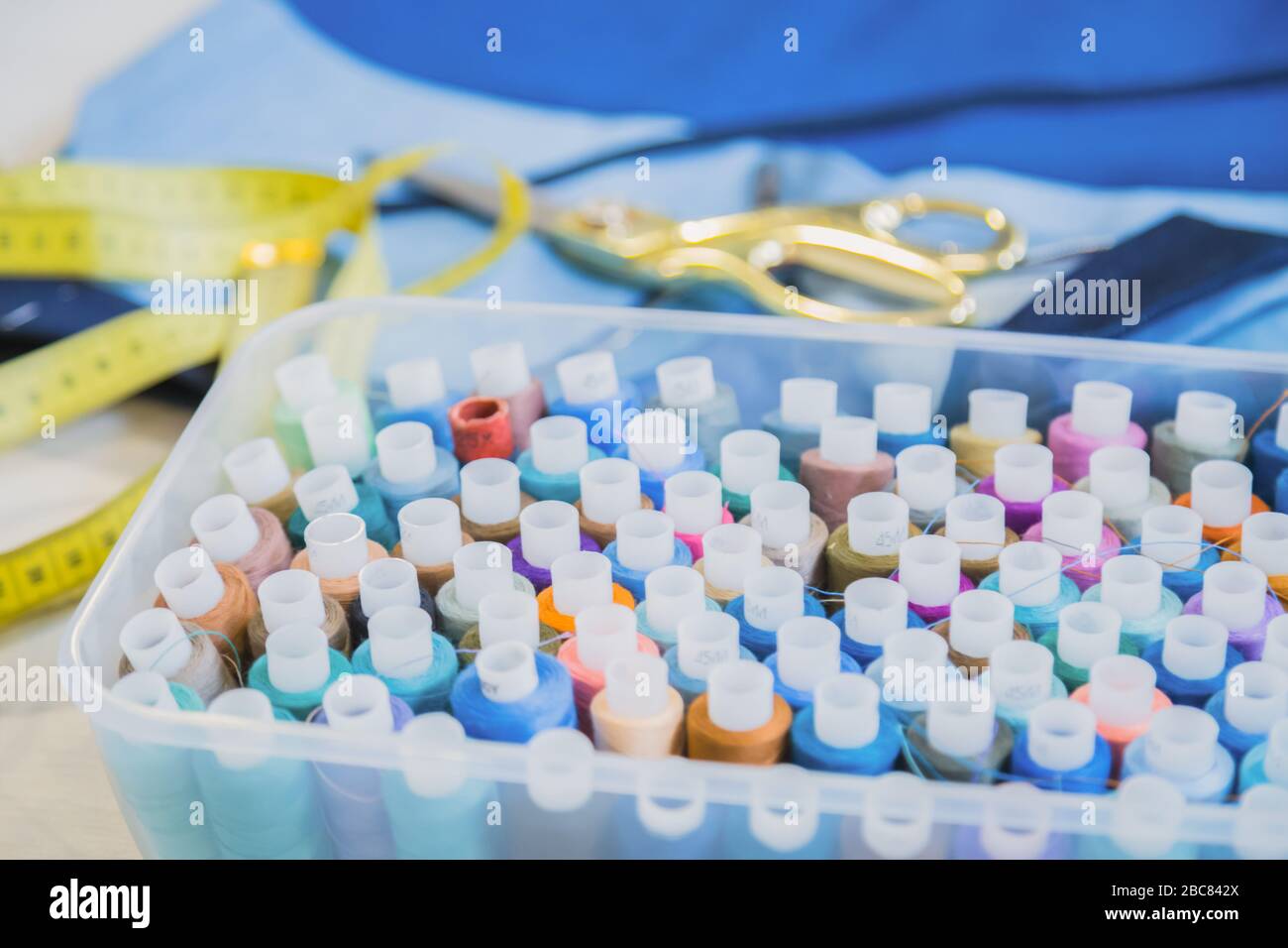 Plastic bobbins, spools with colored thread on table Stock Photo - Alamy