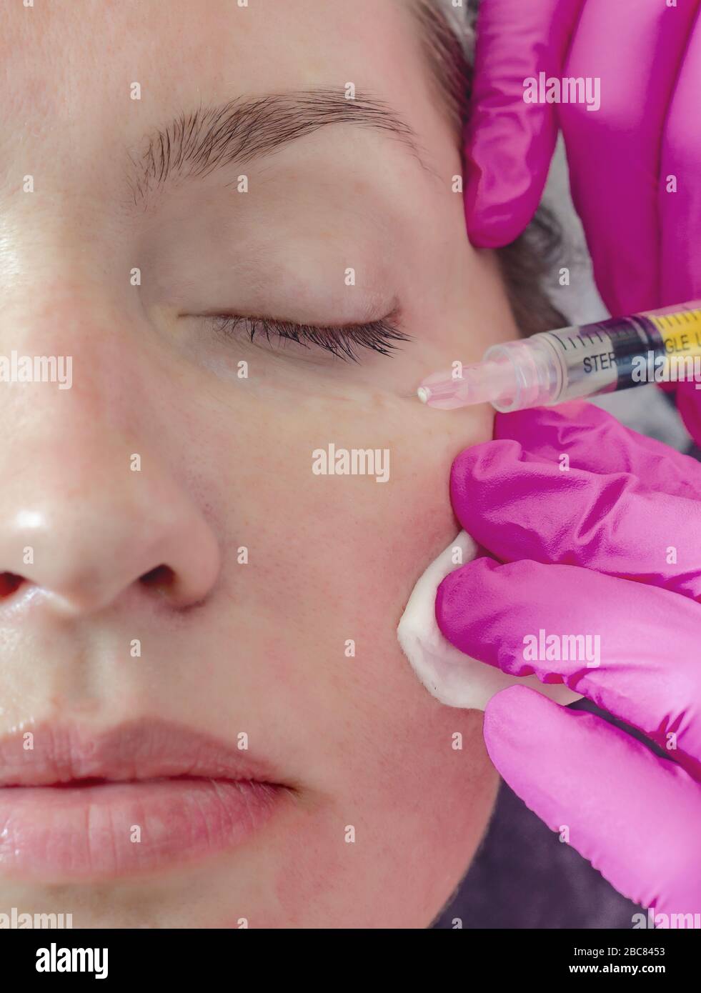 Woman face makes beauty injections around eyes, syringe, medicine ...