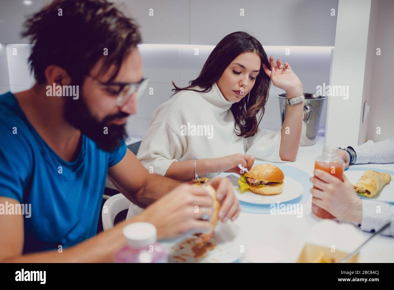 Troubled couple eating dinner with friends in the house Stock Photo - Alamy
