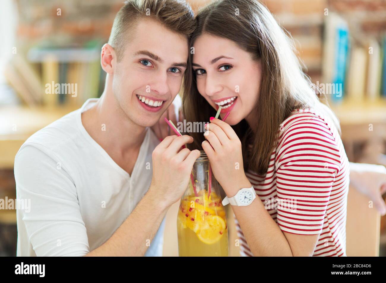Young couple sharing a drink Stock Photo - Alamy