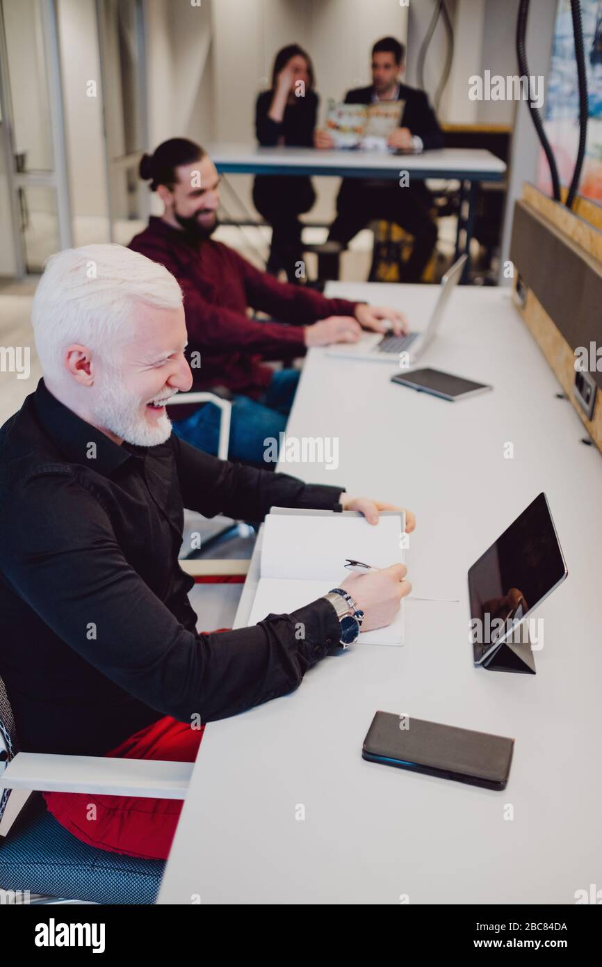Male colleagues laughing in the office while working Stock Photo - Alamy