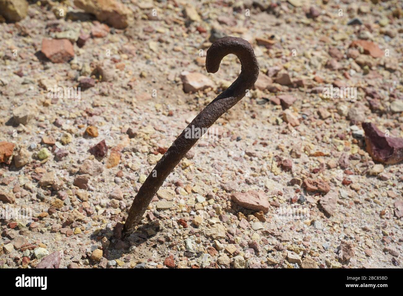 A rusted piece of metal sticks out of the ground at an old mine site ...