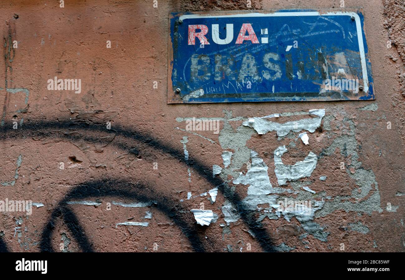Crumbling paintwork and graffiti disfigure a street sign in Rocinha ...