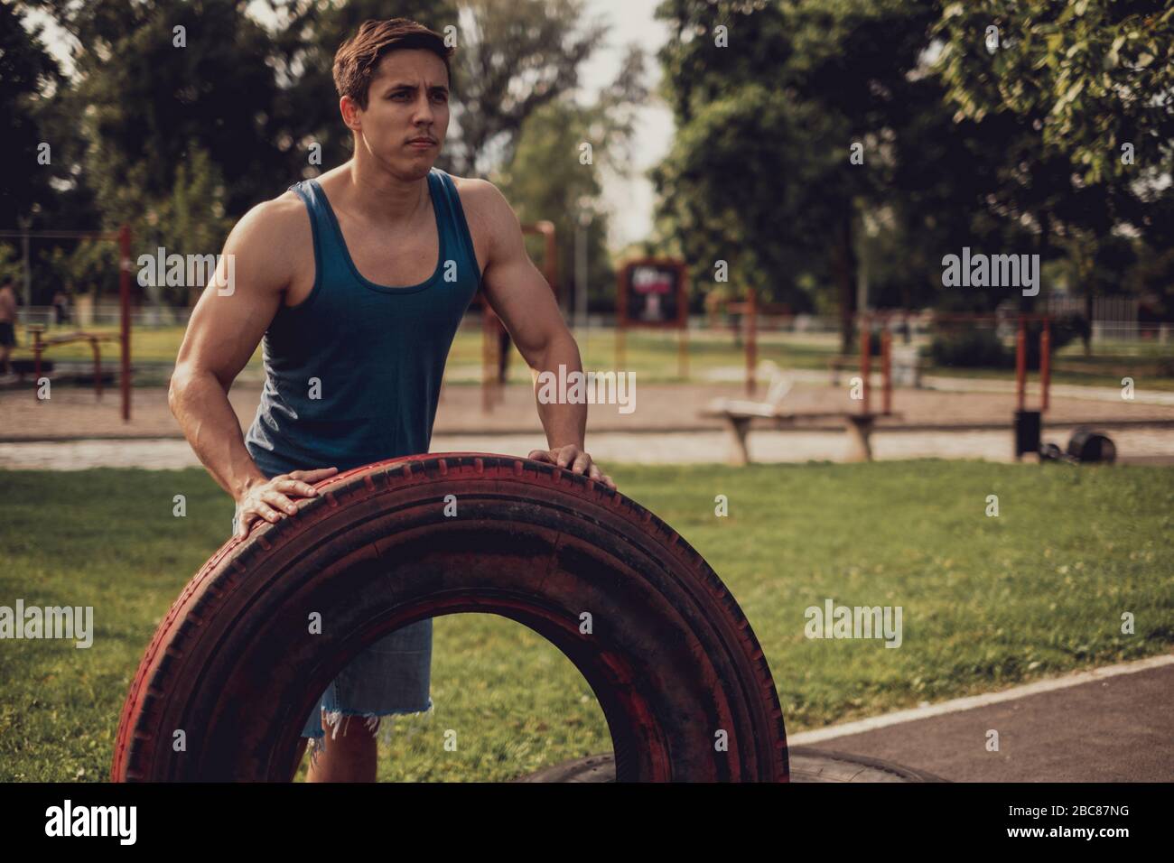 Athletic man standing by training tire in the outdoor gym Stock Photo ...