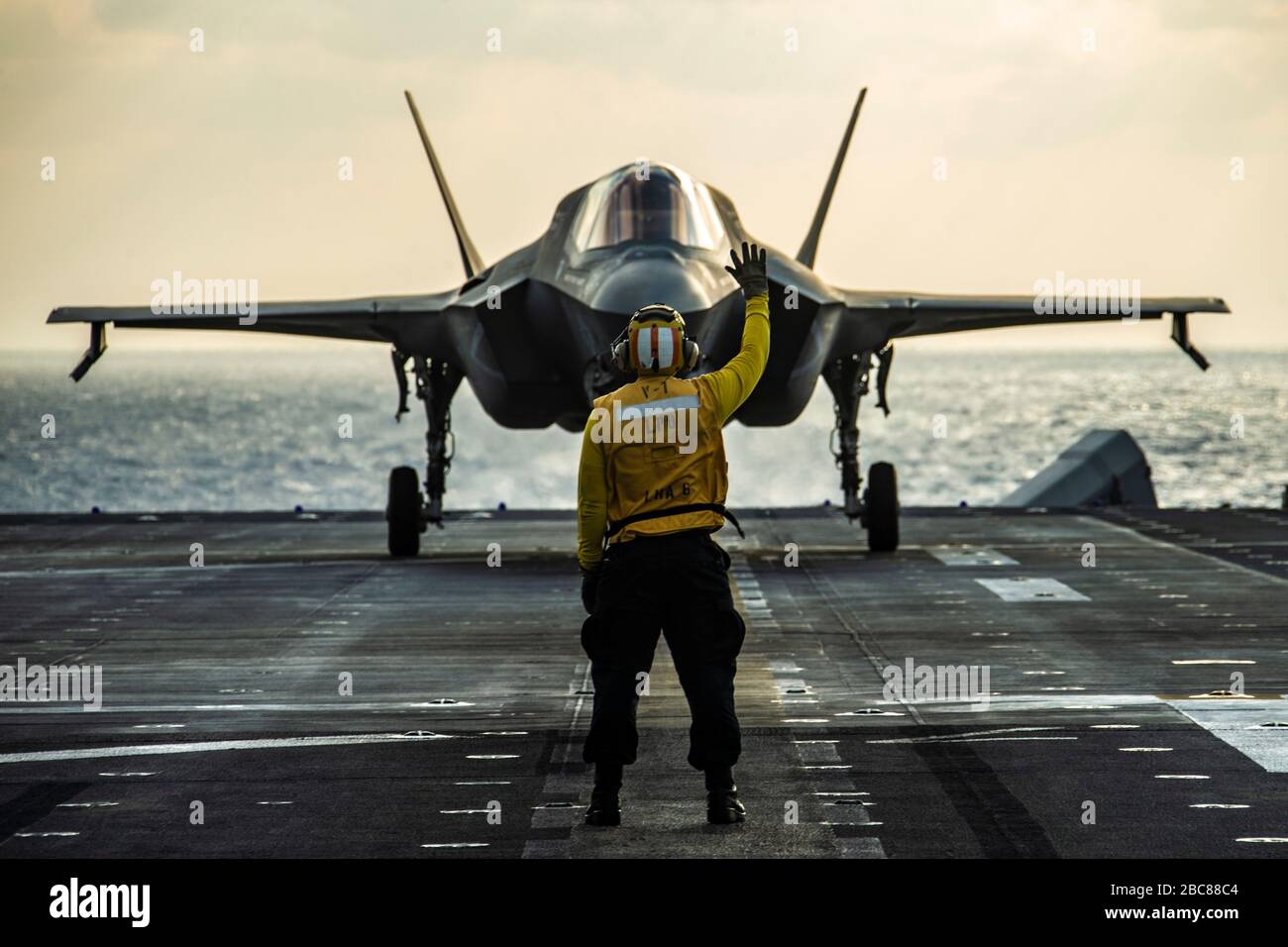 A U.S. Navy yellow jacket signals a Marine Corps F-35B Lightning II ...