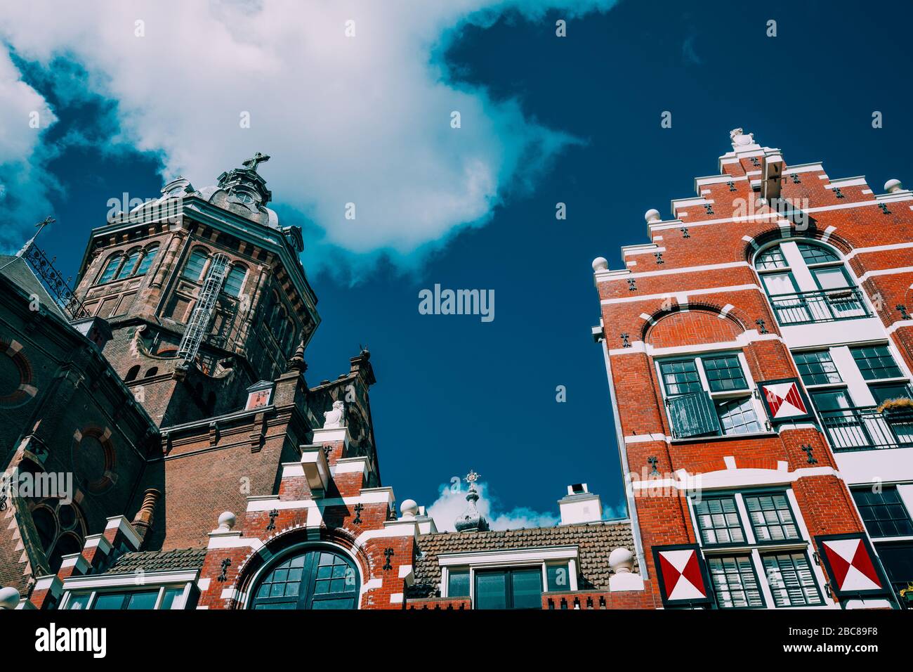 Low angle of traditional dutch house facade and St. Nicolas church in ...