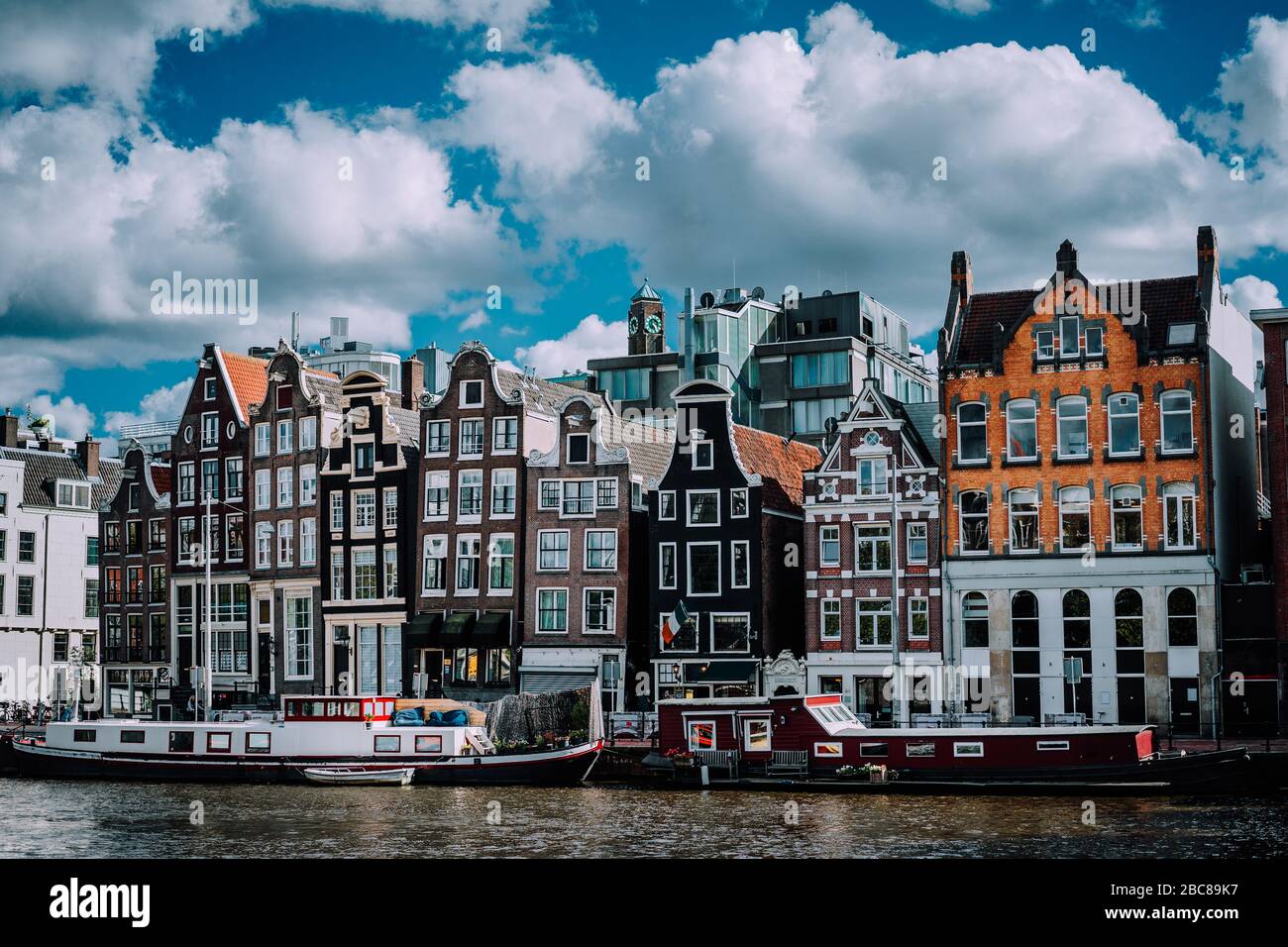 Wonderful architecture of Amsterdam. White fluffy clouds over Leaning ...