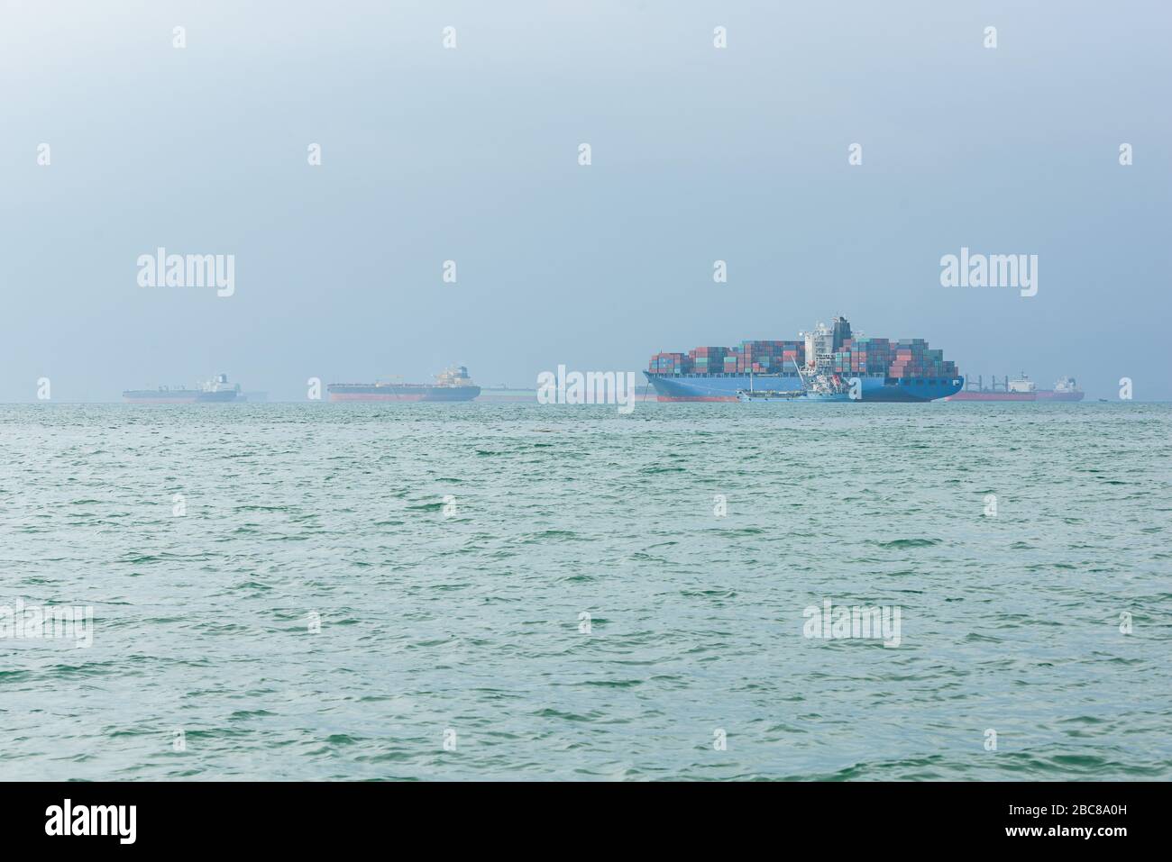 Cargo ships, oil tankers and bulk carriers anchored offshore along the ...