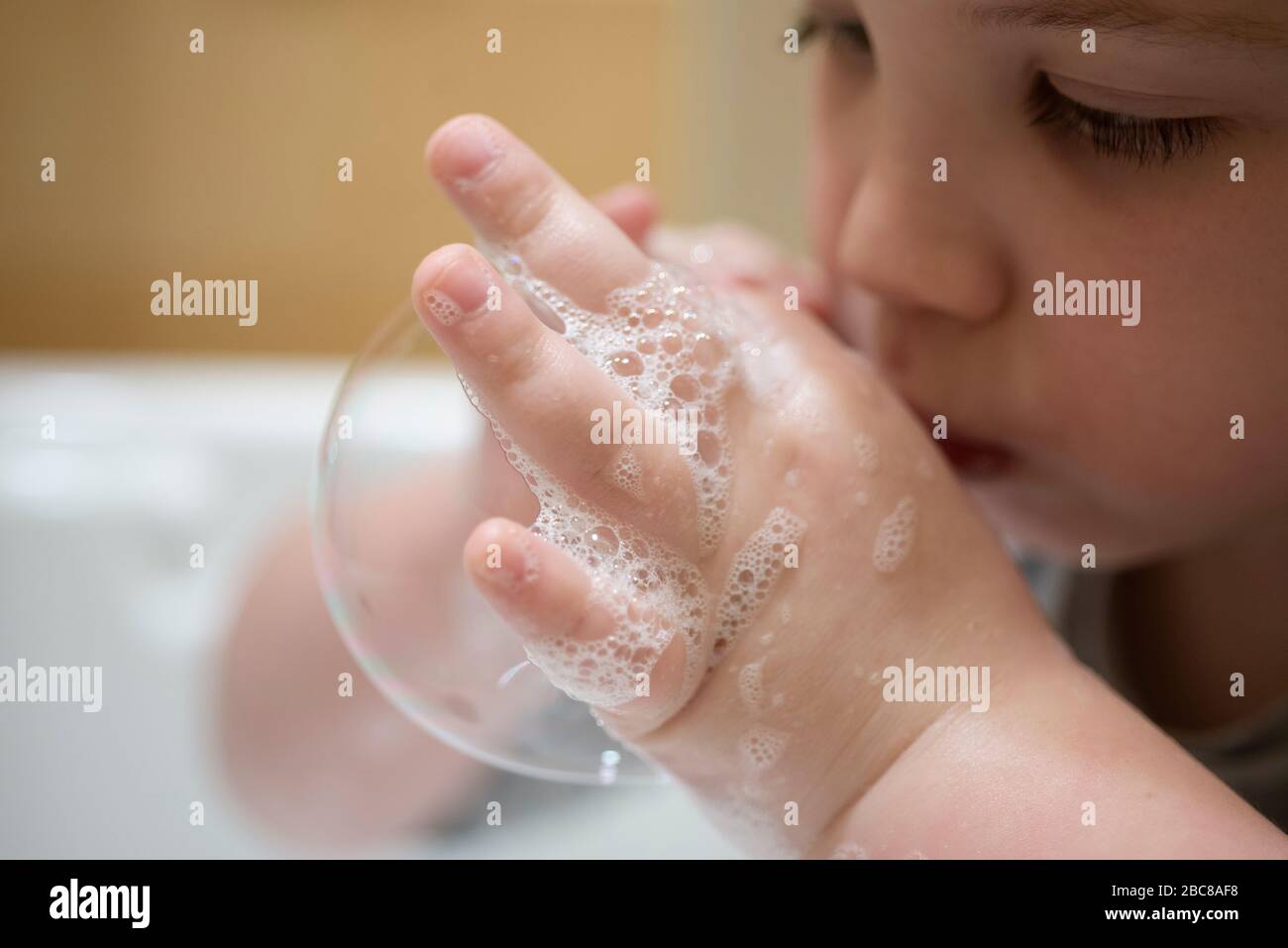 Young Boy Blowing a Soap Balloon Stock Photo - Alamy