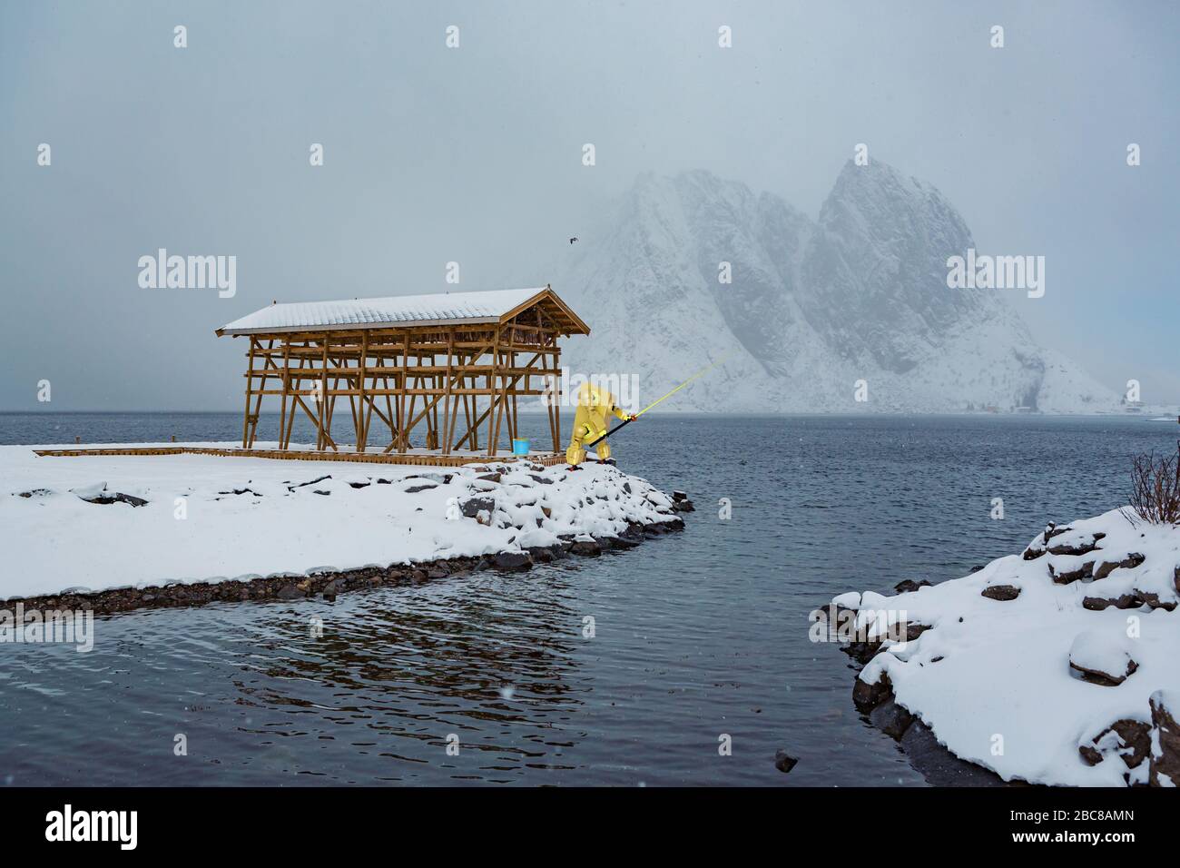 A patient robot fishing with a rod in the fjord Stock Photo - Alamy
