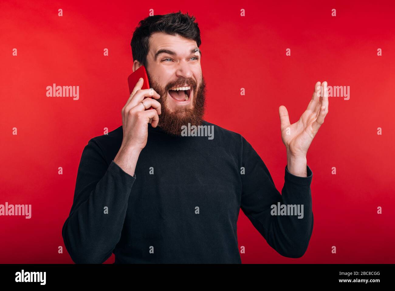 Photo of angry man screaming and talking on smartphone while standing ...