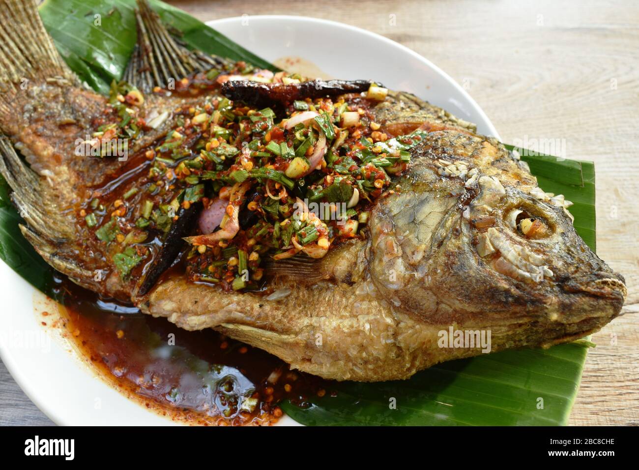 fried mango fish dressing spicy sauce and fresh vegetable Stock Photo ...