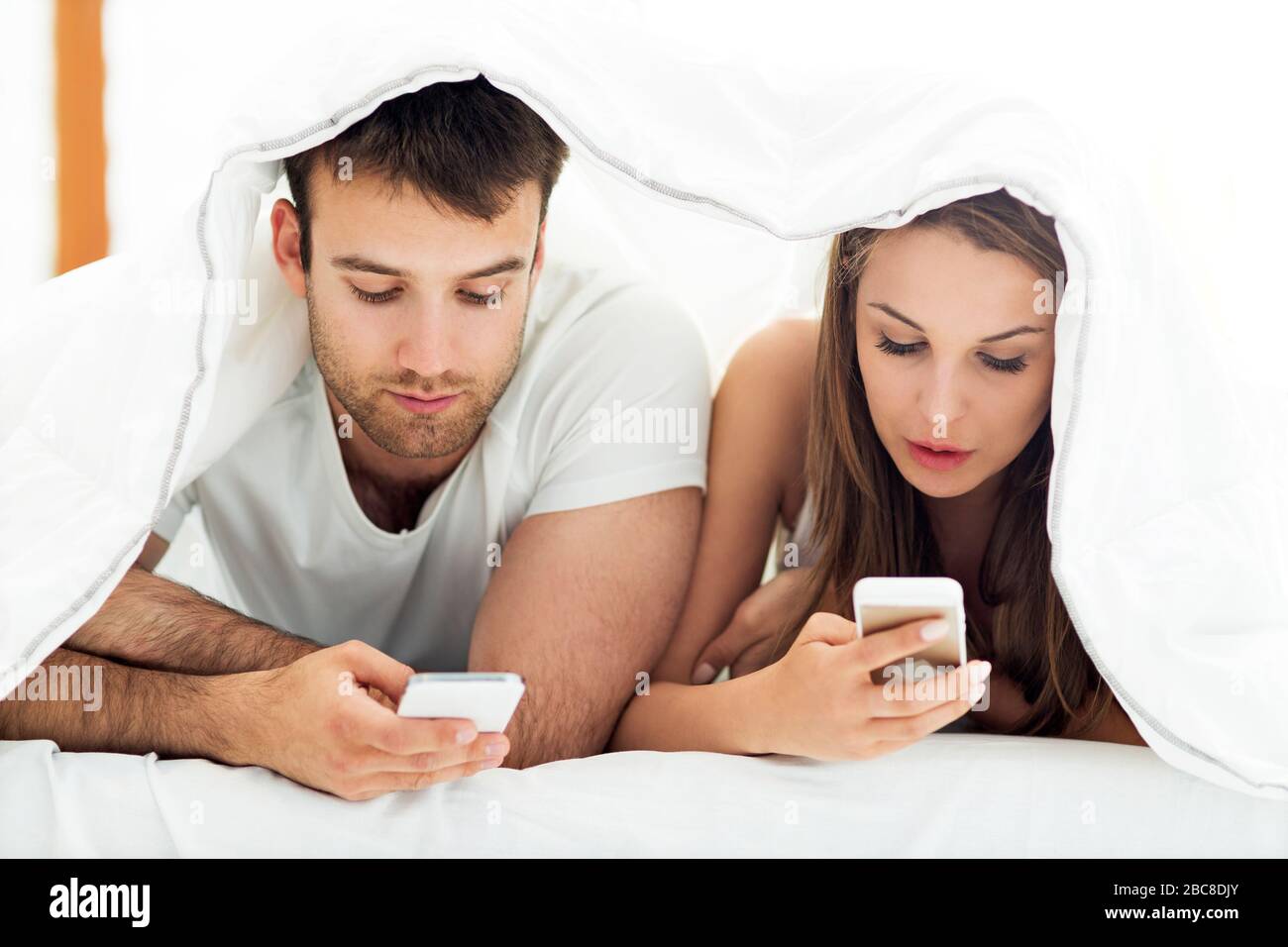 Couple under covers in bed hi-res stock photography and images - Alamy