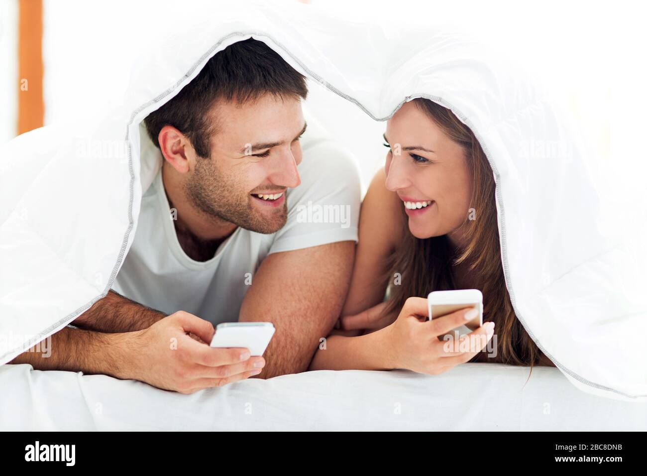 Couple using smartphone together home hi-res stock photography and ...