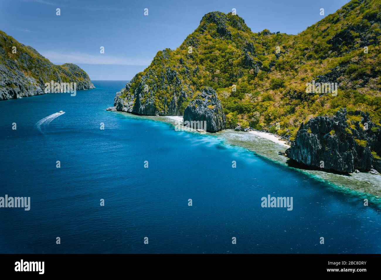 Limestone karst coastline of Matinloc Island with tourist boats in ...
