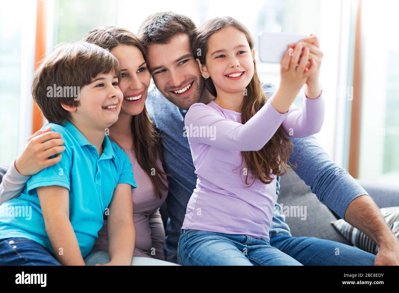 Young family relaxing at home Stock Photo - Alamy