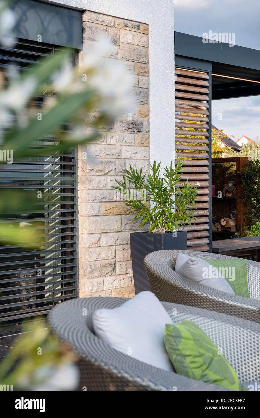 Artificial rattan garden furniture in front of a modern house facade ...