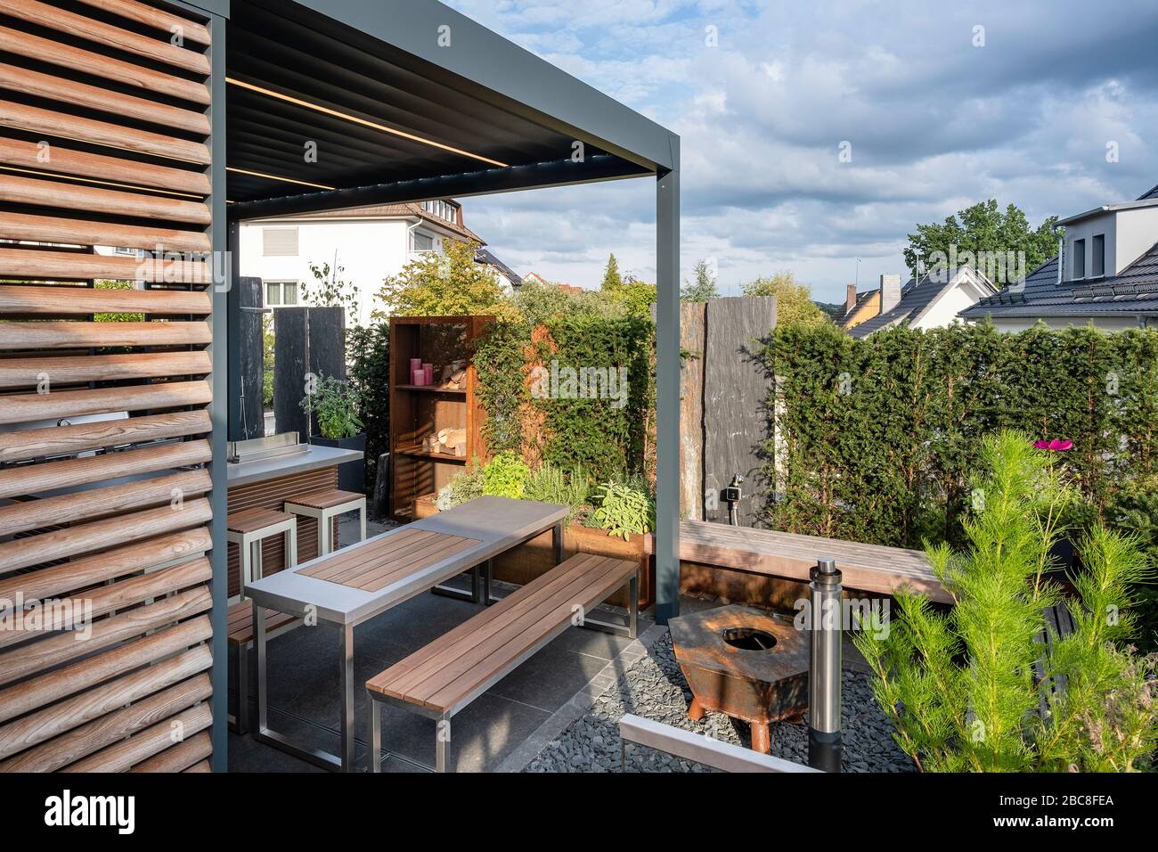 Modern covered terrace with seating and fireplace Stock Photo - Alamy