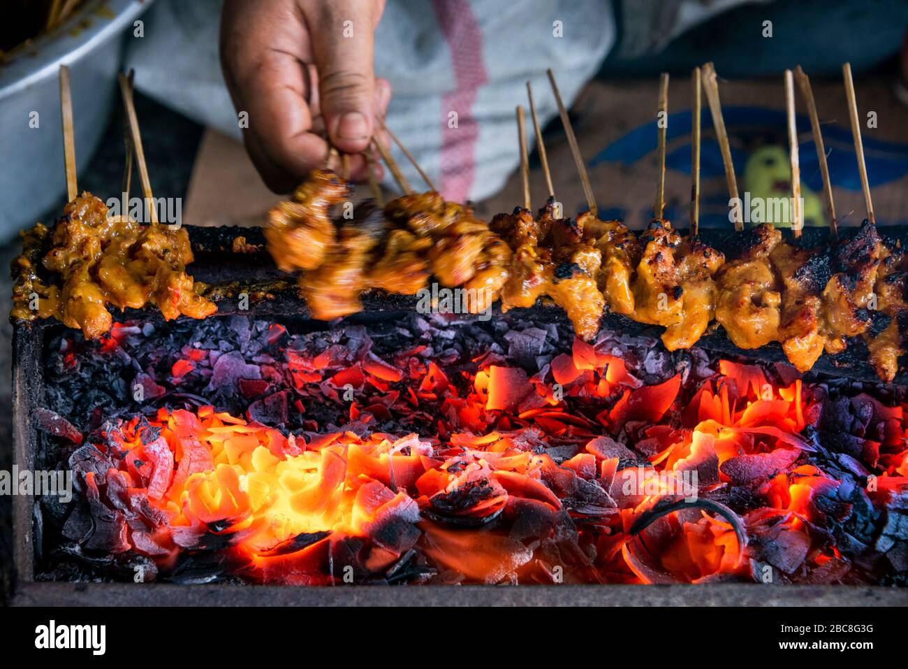 Horizontal close up of satay, a traditional dish in Bali, being cooked ...