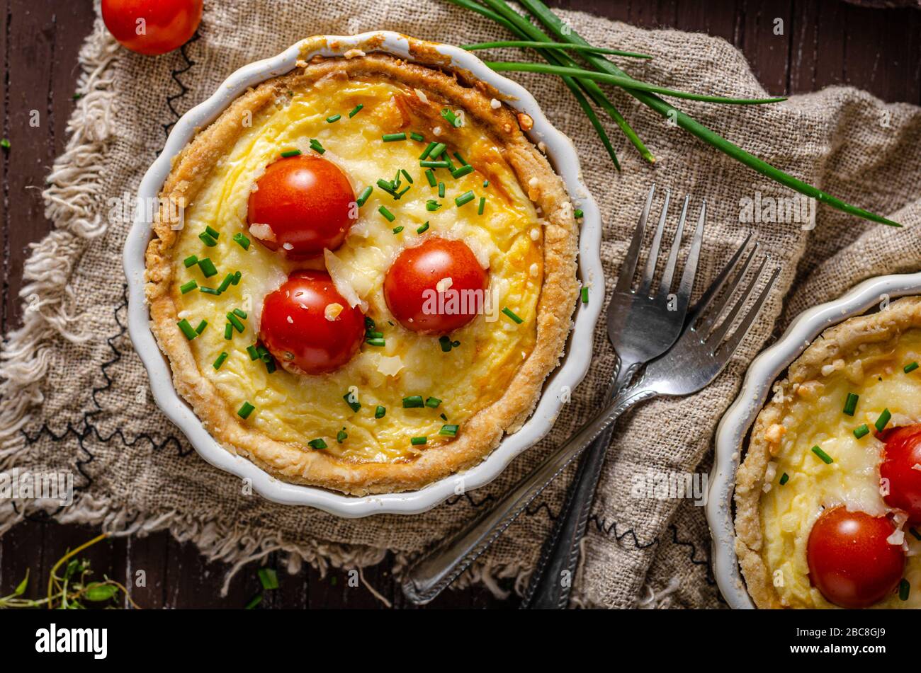 Rustic cheese quiche with bio cocktail tomatoes Stock Photo - Alamy