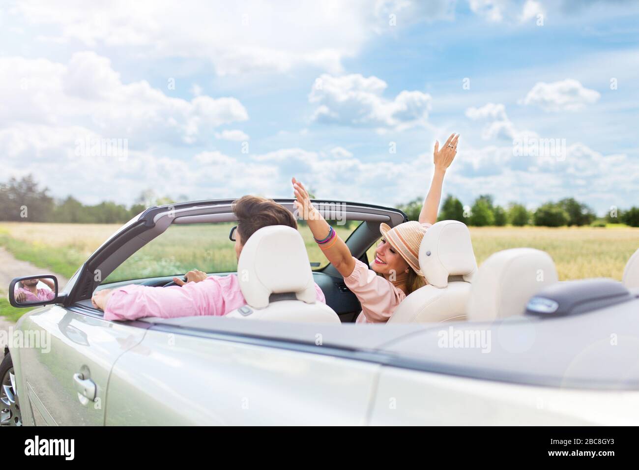 Couple enjoying a drive in a convertible Stock Photo - Alamy