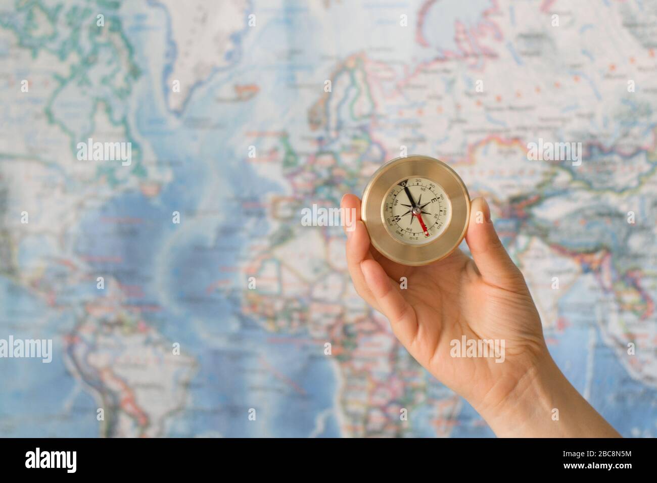 Hand holding compass on the background of map Stock Photo - Alamy