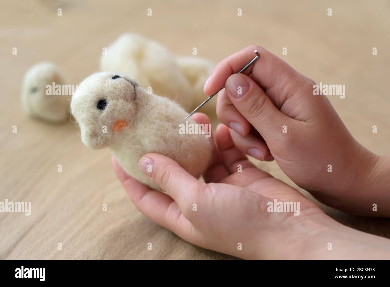 Process of felting a toy from a wool on a wooden background Stock Photo ...
