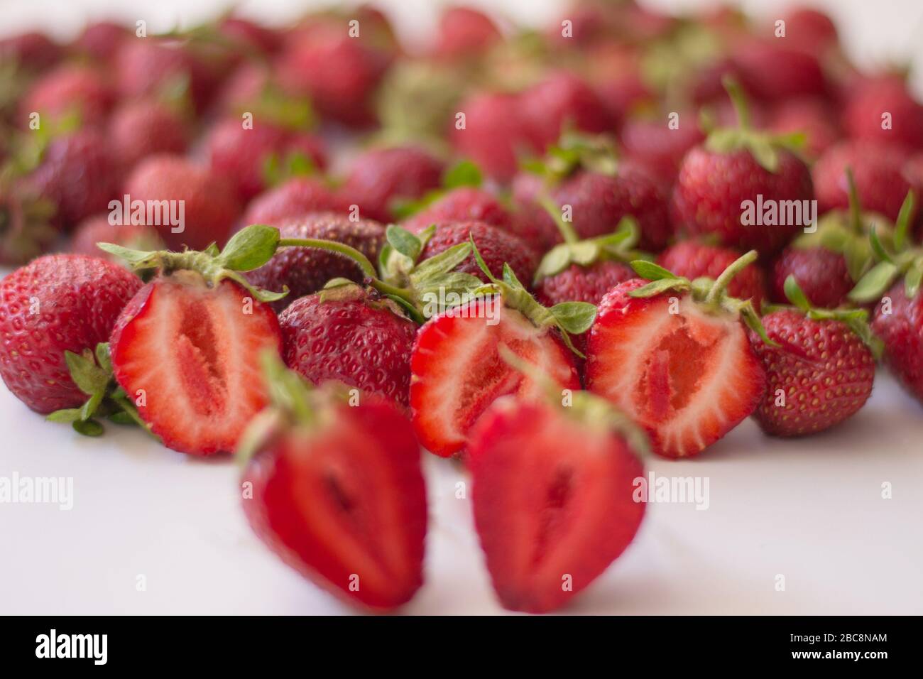 Two halves of a ripe strawberry on a light background Stock Photo - Alamy