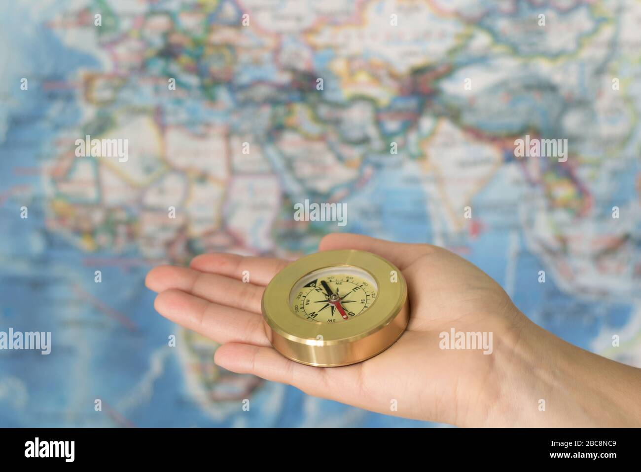 Hand holding compass on the background of map Stock Photo - Alamy