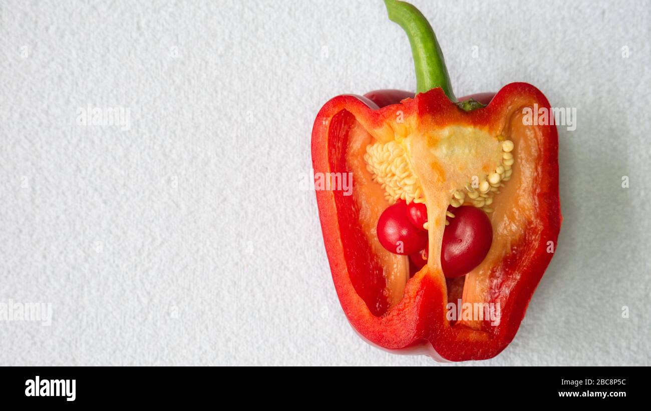 Two small bell peppers growing inside a red one, white glitter backdrop ...