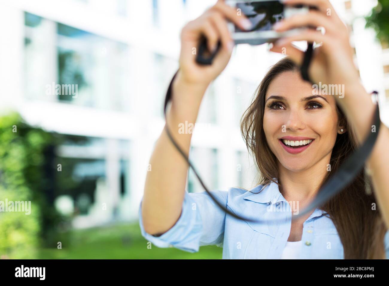 Woman taking photo smiling hi-res stock photography and images - Alamy