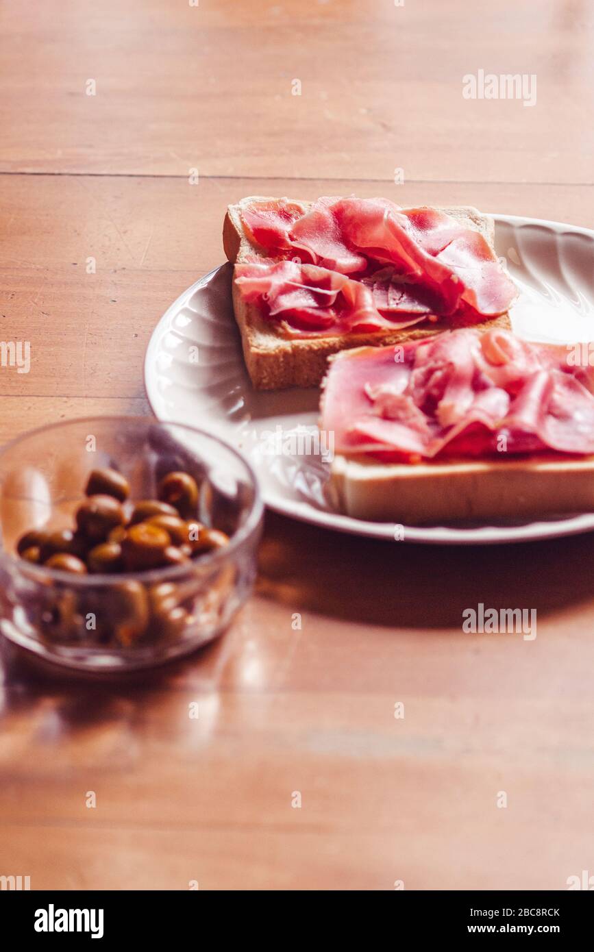 Green olives and toast with serrano ham, traditional spanish snack ...