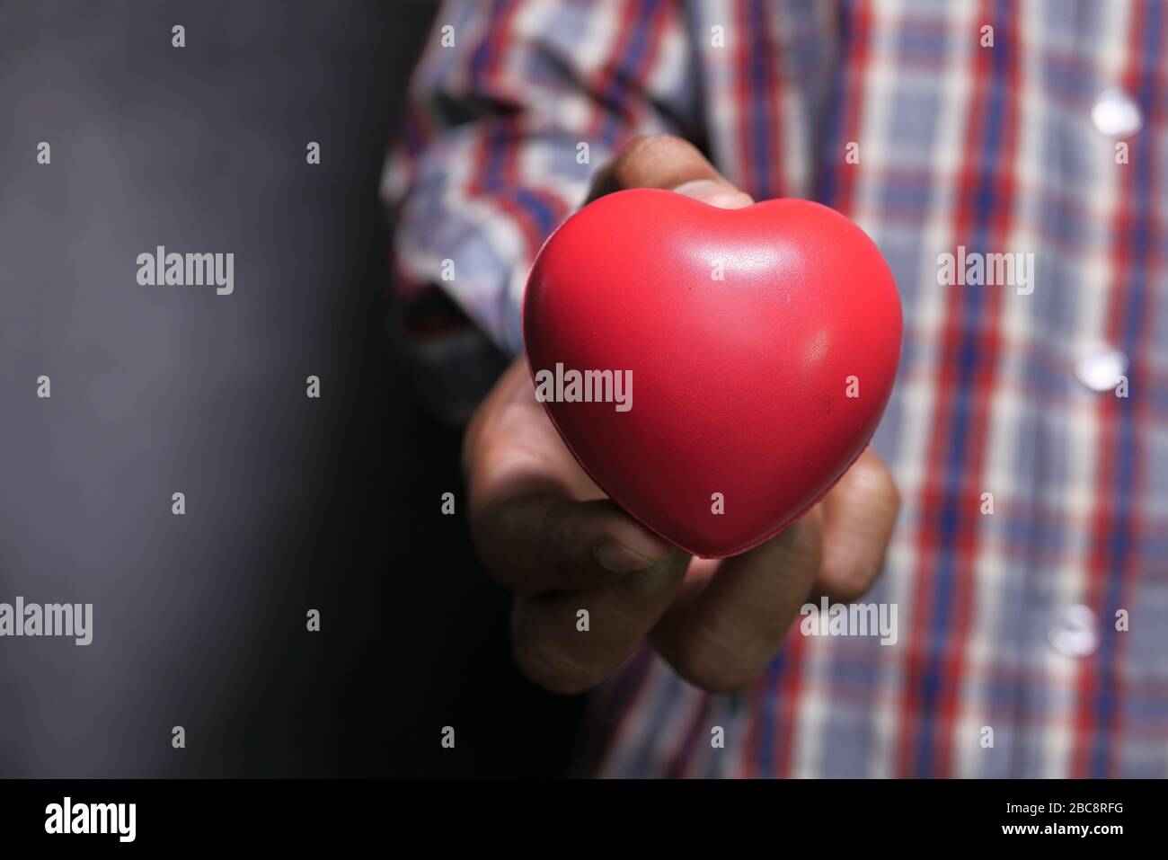 man hand holding heart shape symbol, close up Stock Photo - Alamy