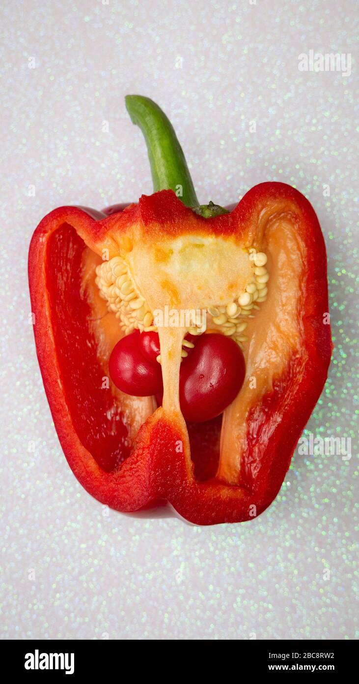 Two small bell peppers growing inside a red one, white glitter backdrop ...