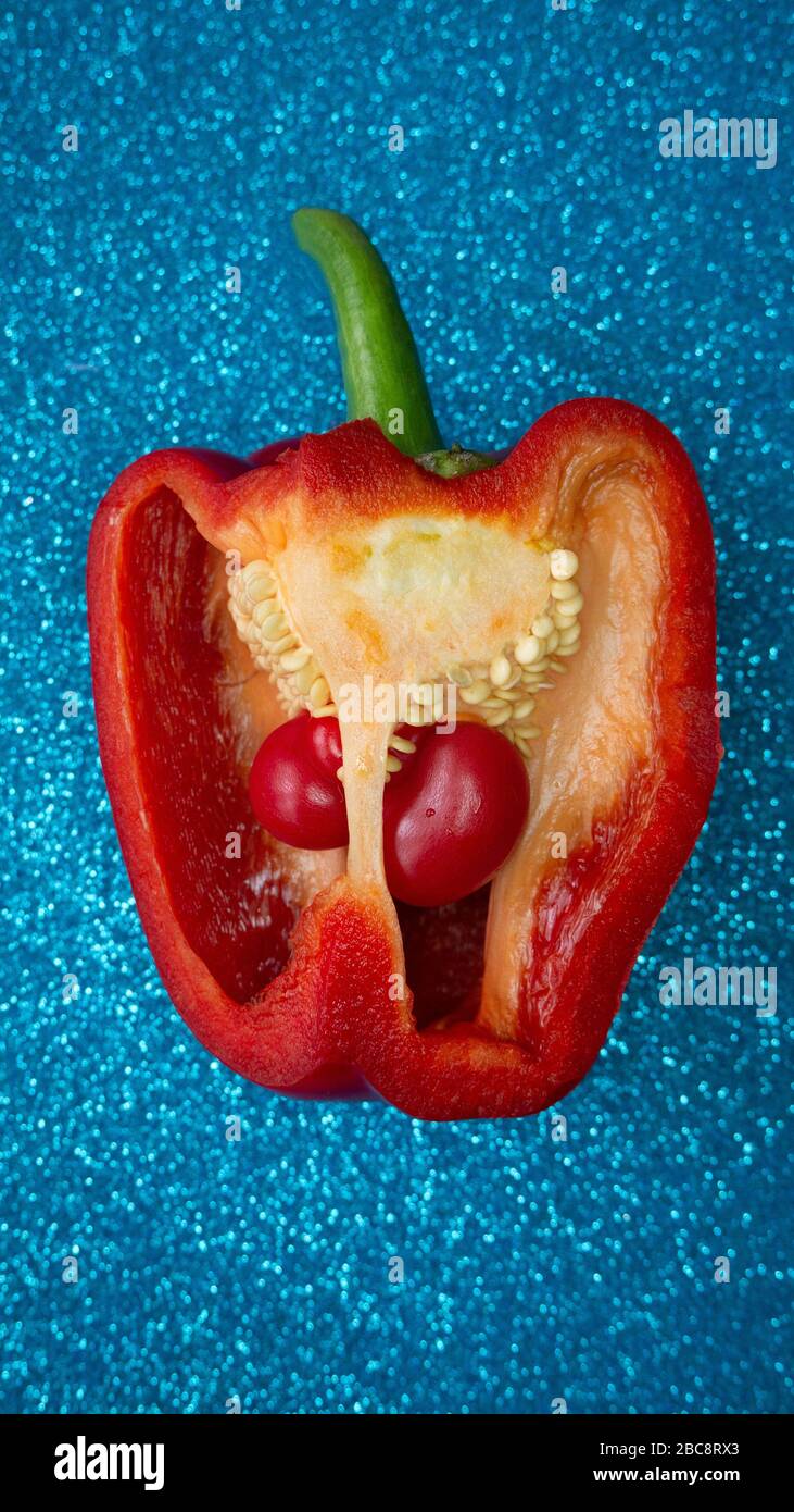 Red pepper cut in half with small paprika inside, blue glitter ...