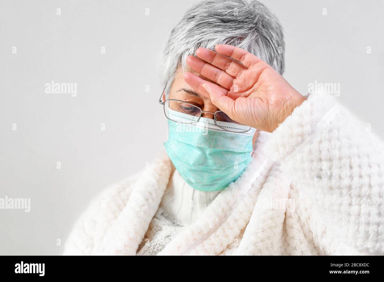 Covid-19. Sick senior woman portrait, wearing face protection mask ...