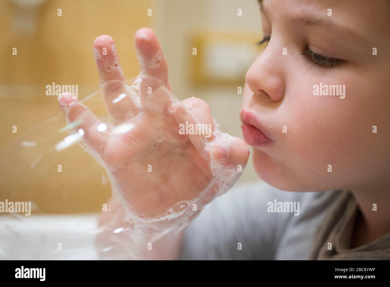 Young Boy Blowing a Soap Balloon Stock Photo - Alamy