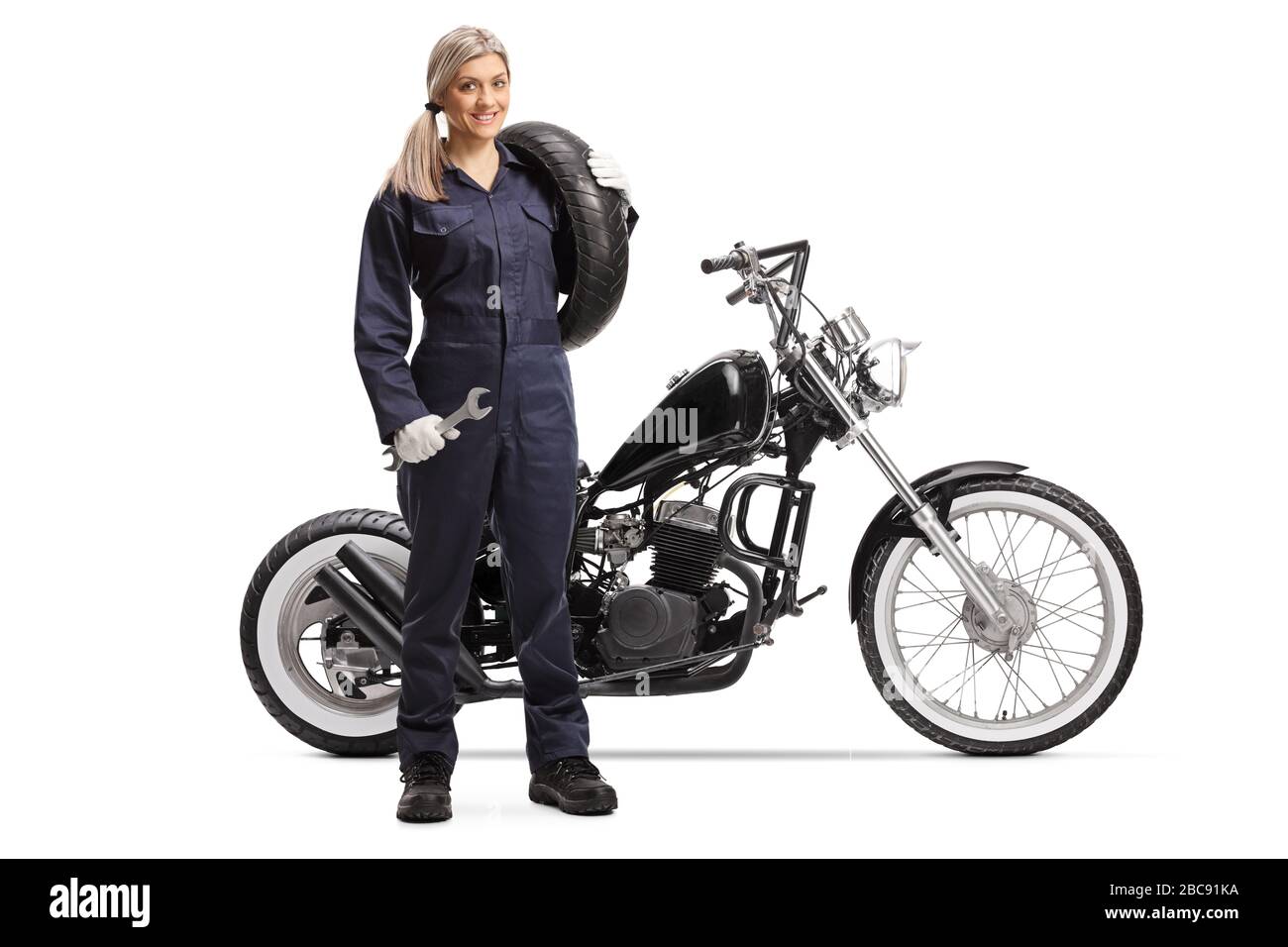 Full length portrait of a female mechanic standing next to a custom ...