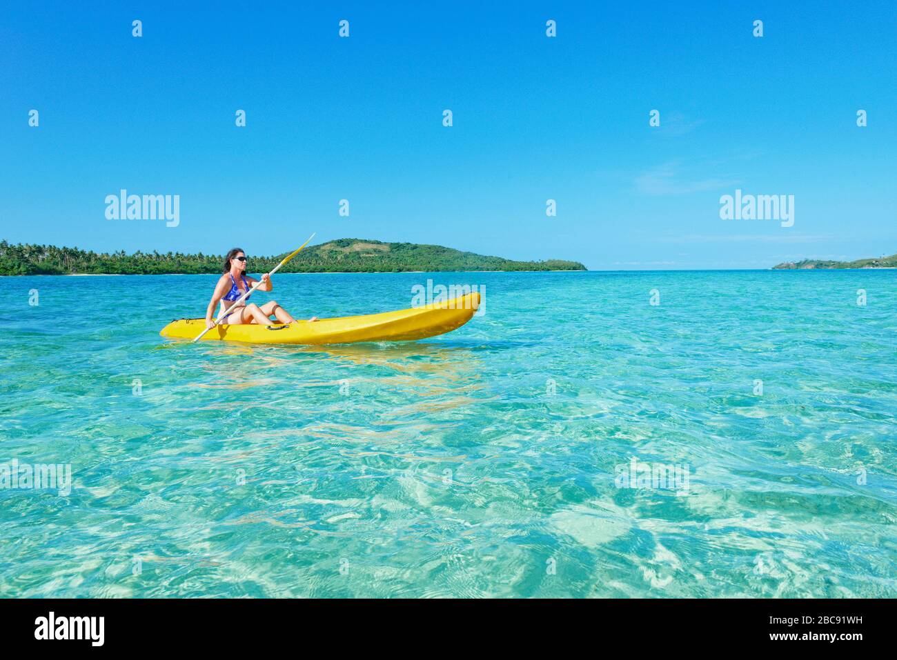 Woman sea kayaking in Fiji turquoise water, Matacawalevu Island, Fiji ...