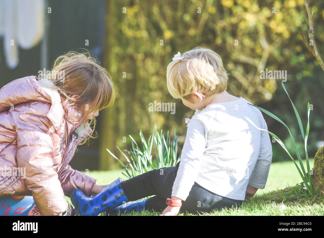 Siblings playing together a boy and girl are playing outside in a ...
