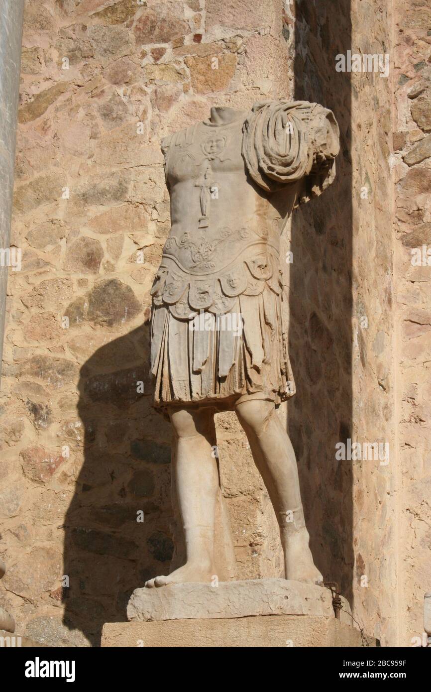 Roman ruins in strong sunlight with headless statue of roman soldier ...