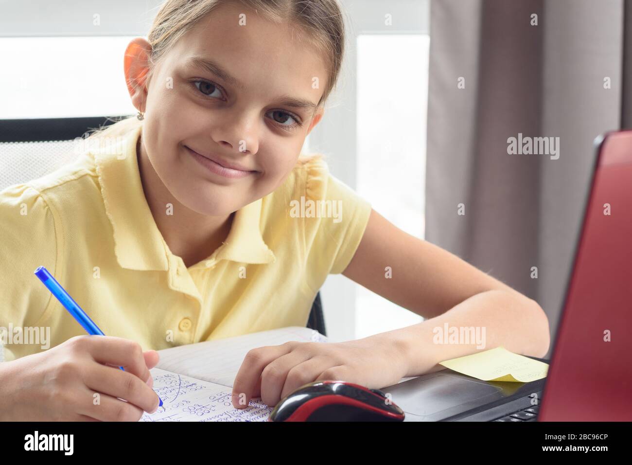 Closeup portrait of happy girl doing homework in front of computer ...