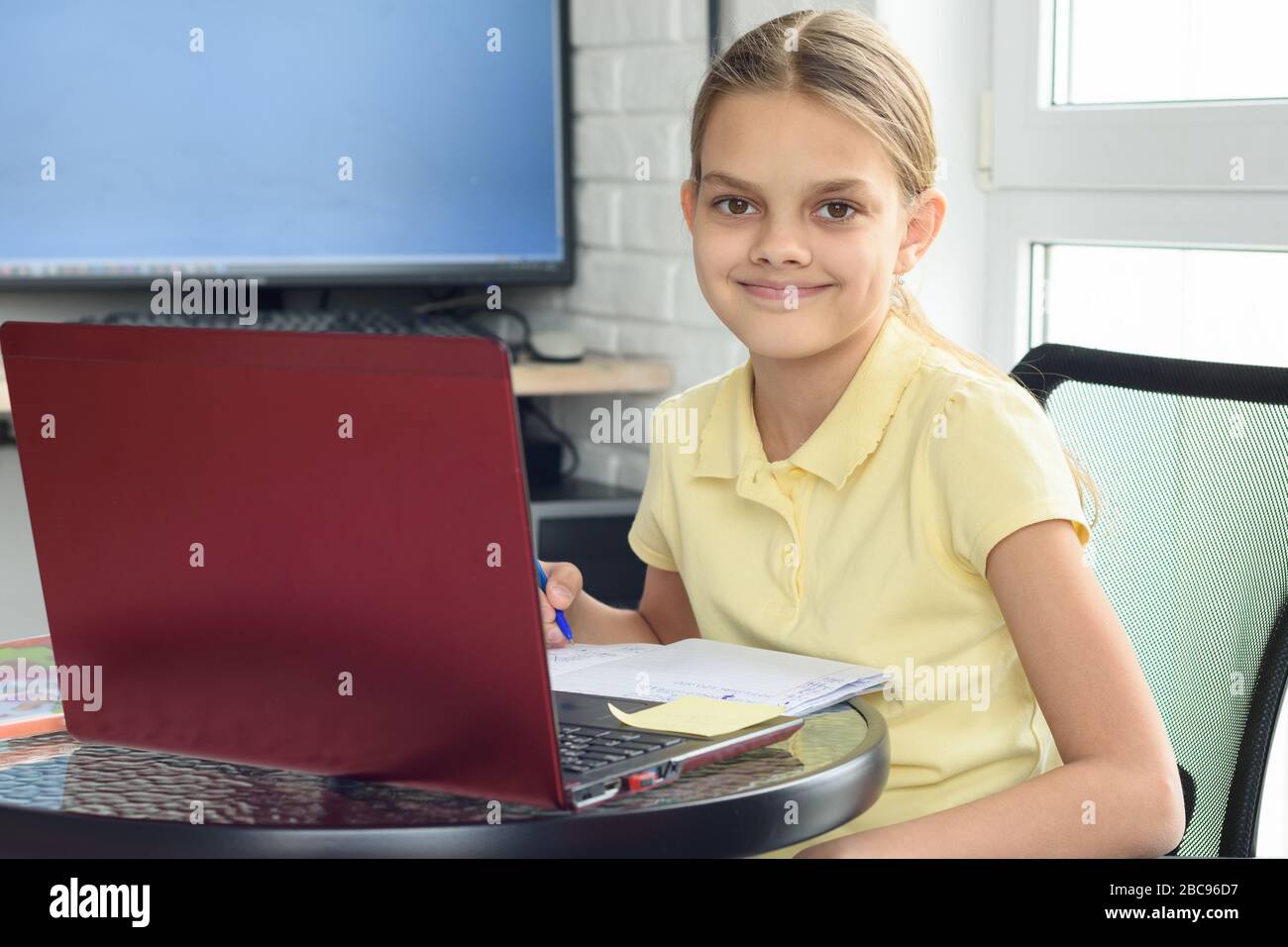 Happy girl sitting in front of a laptop and studying remotely Stock ...