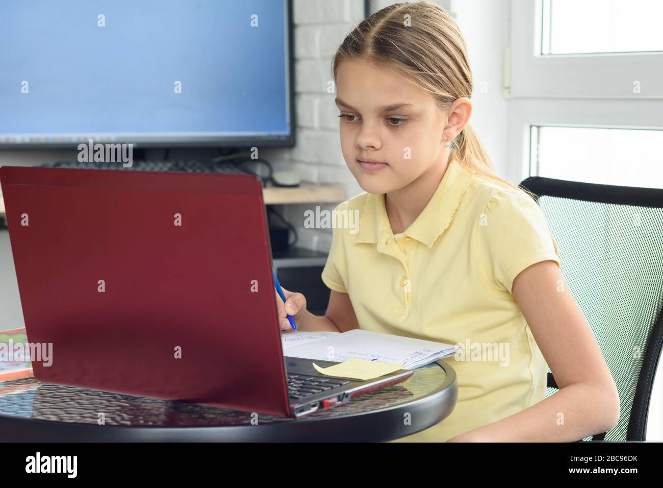 Pretty girl of Caucasian appearance at the computer does homework Stock ...