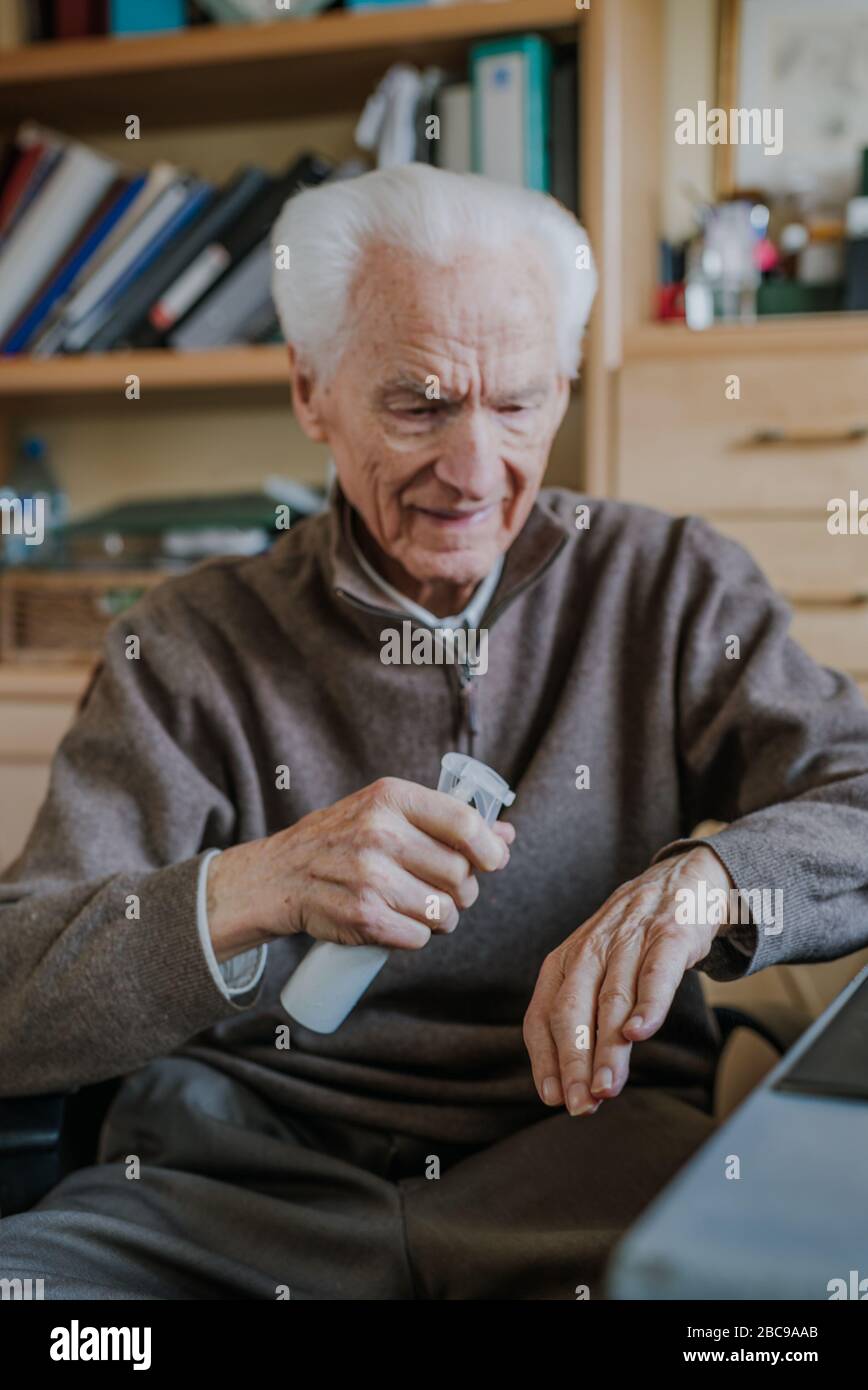 Senior disinfects hands with antibacterial liquid, hand washing ...