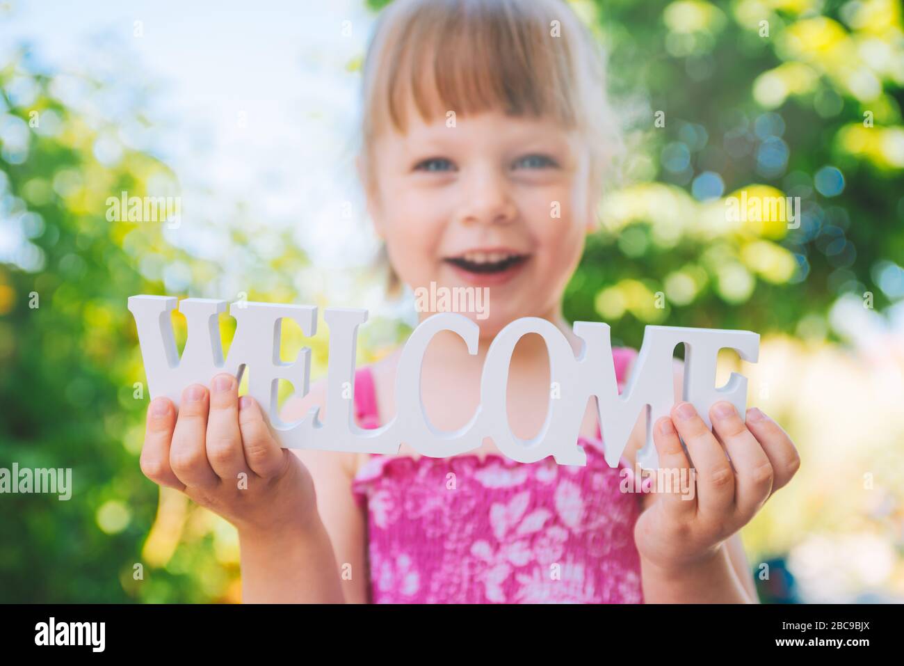 Little toddler - laughing girl in a pink dress holding the words ...