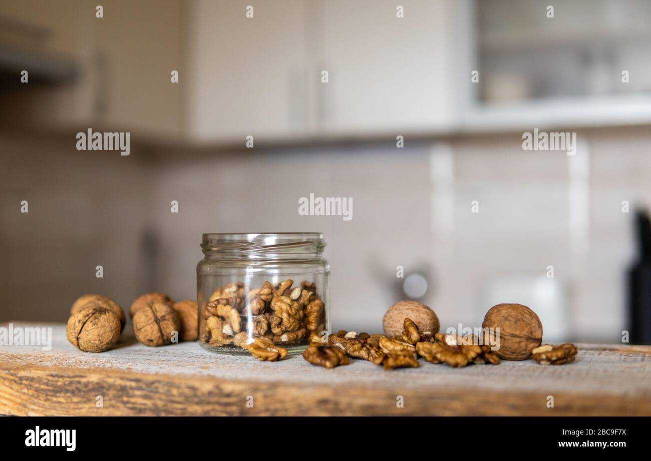 Walnut in a jar and scattered nuts which standing on a white vintage ...