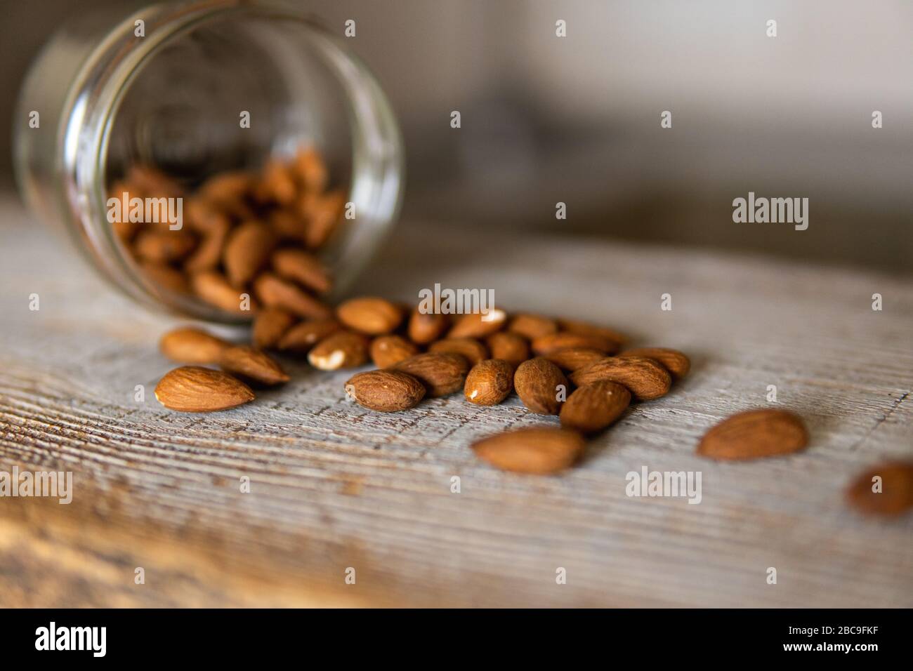Almonds scattered on the white vintage table from a jar. Almond is a ...