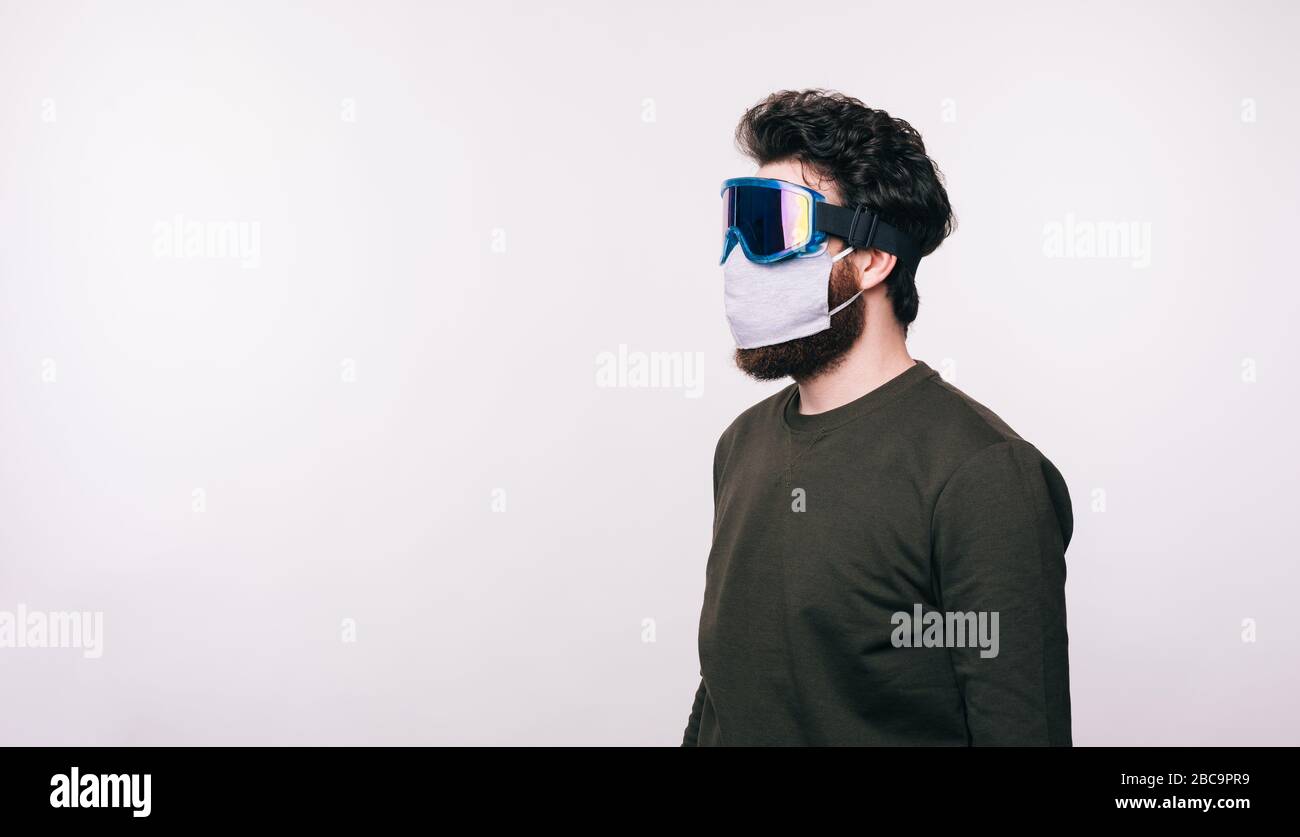 Side view Photo of man with facial mask standing over white background ...