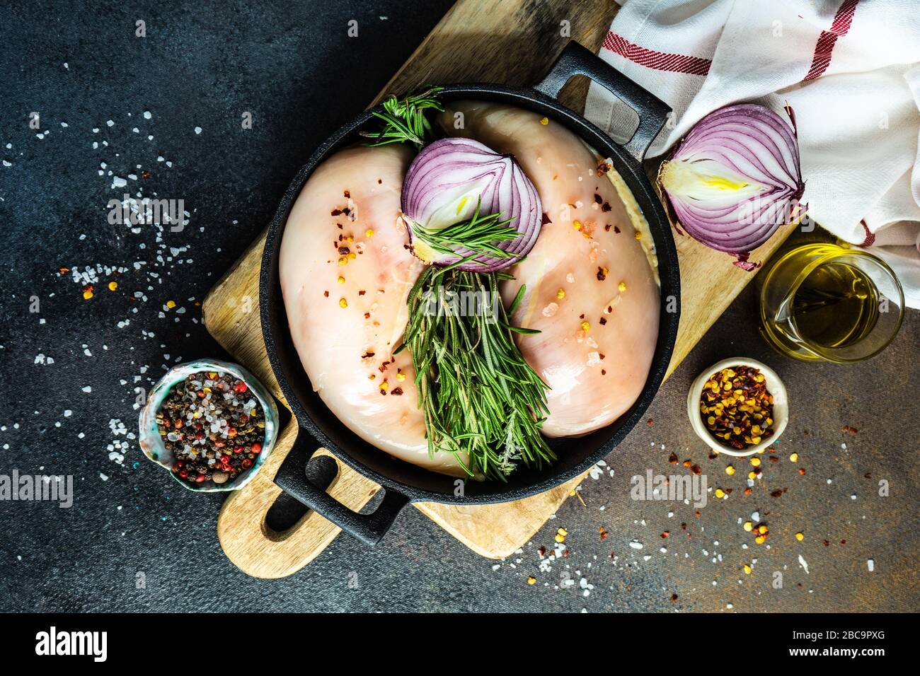 Keto diet concept with raw chicken meat with fresh vegetable and herbs ...